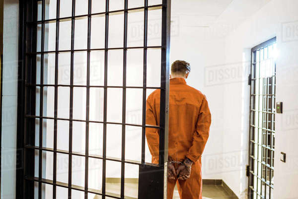 back view of prisoner standing in handcuffs in corridor - Royalty-free ...