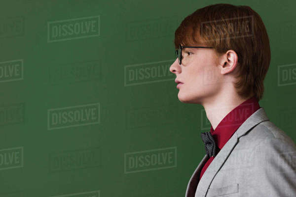 Side view of male fashion model in eyeglasses isolated on green ...