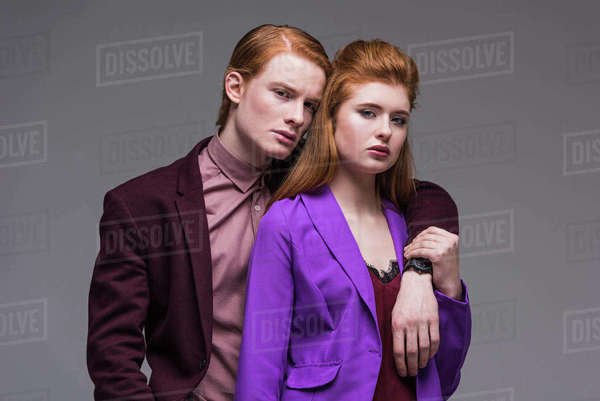 Couple of fashion models in formal wear isolated on grey - Stock Photo ...