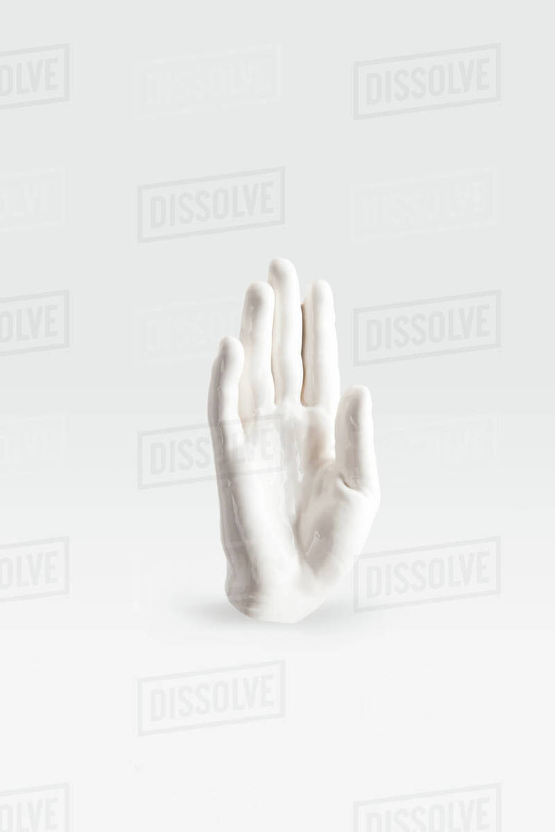 Abstract sculpture in shape of human arm in white paint on white ...