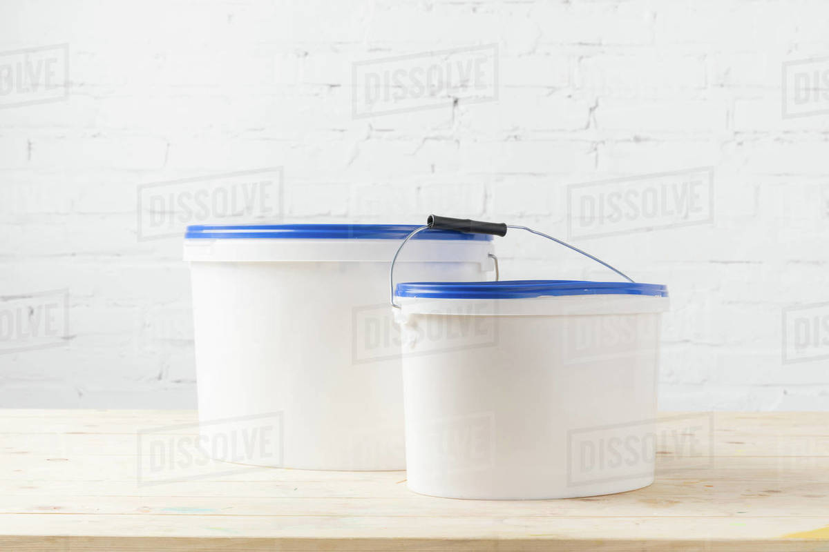 Two plastic buckets with paints on wooden surface - Royalty-free Stock ...