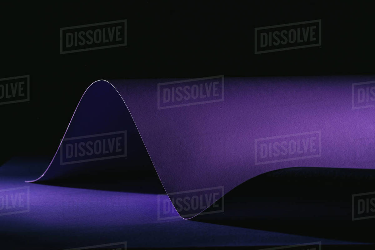 Warping purple paper on purple surface on black - Royalty-free Stock ...