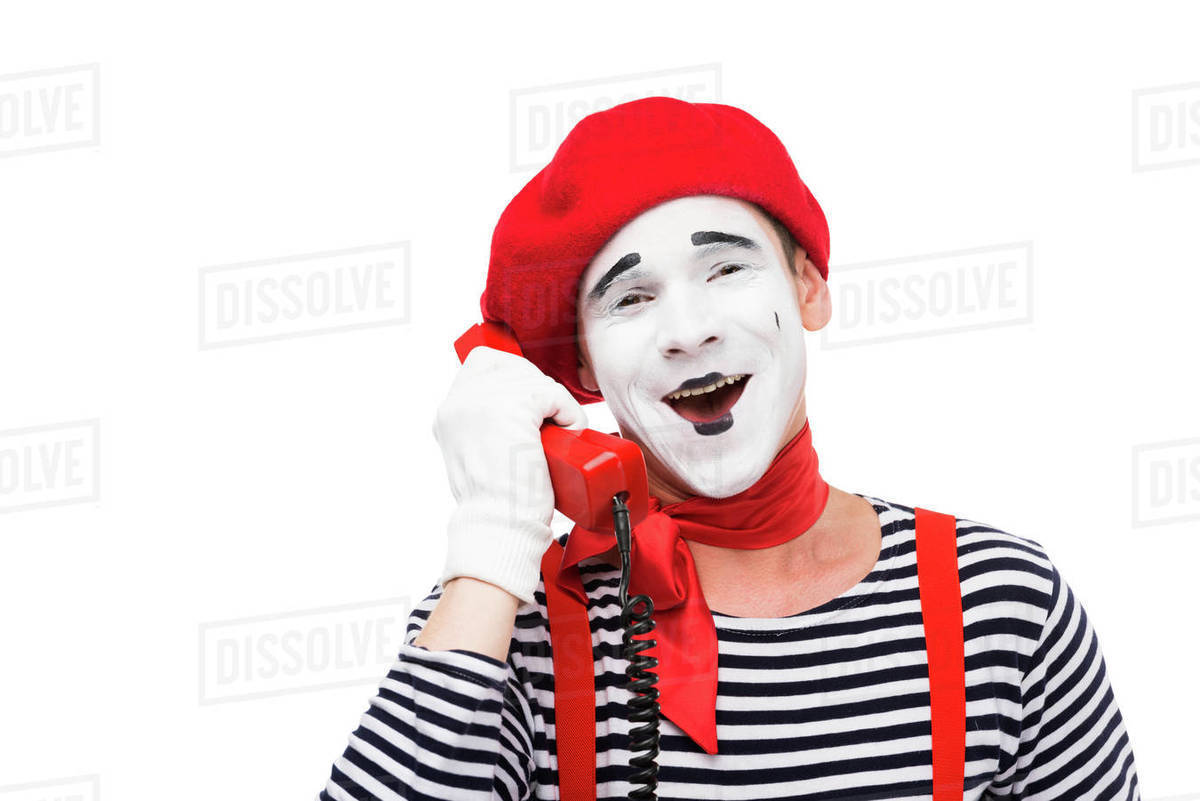 Smiling mime talking by stationary telephone isolated on white ...