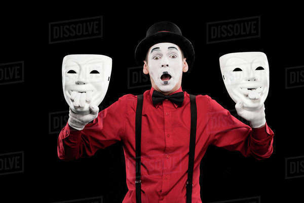 Shocked mime holding two masks isolated on black - Royalty-free Stock ...