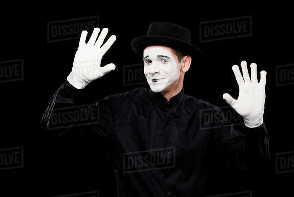 Smiling mime performing and touching something isolated on black ...