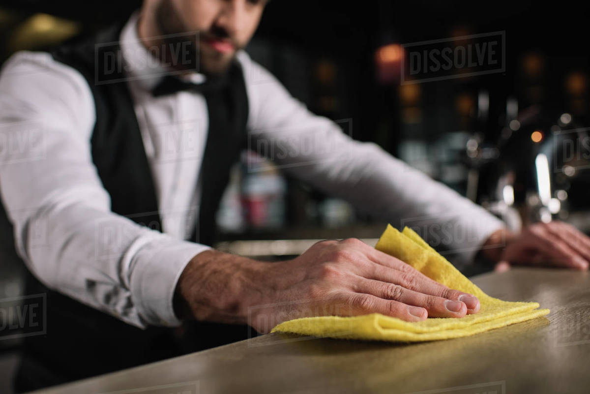 Cropped image of bartender cleaning bar counter in evening - Royalty ...