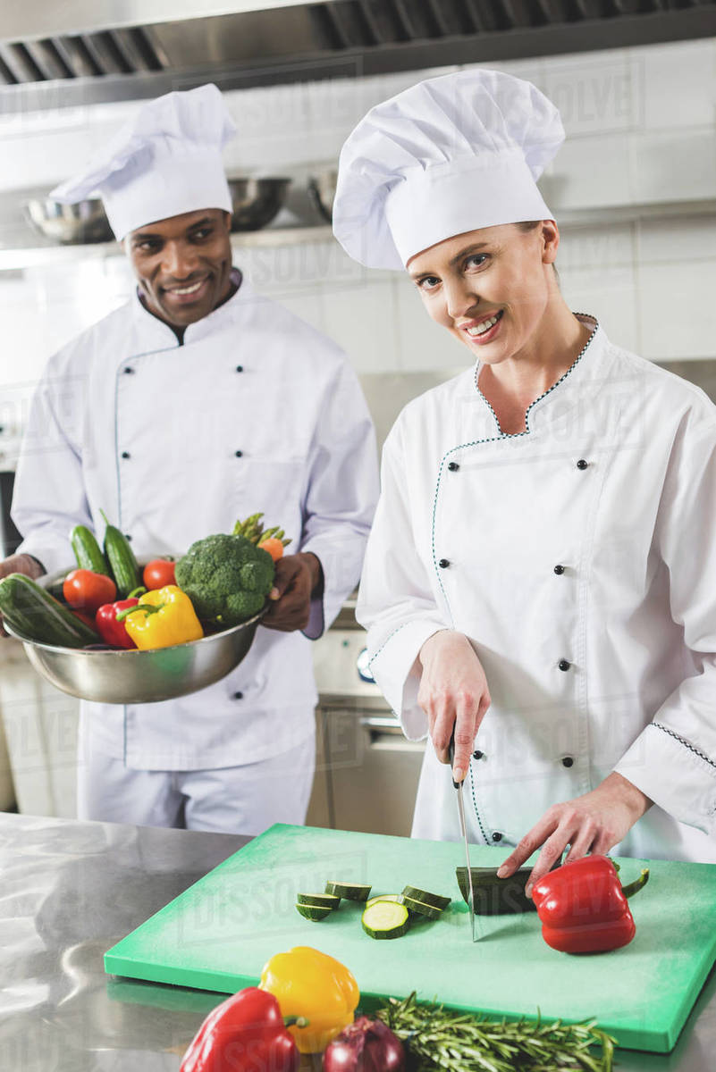 Smiling multicultural chefs cooking at restaurant kitchen - Royalty ...