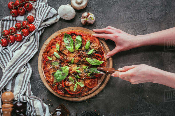 Cropped shot of woman cutting pizza with knife - Royalty-free Stock ...