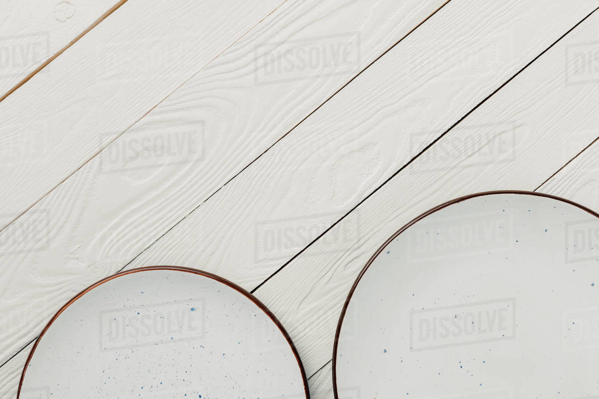 Empty glazed plates on white wooden background - Royalty-free Stock ...