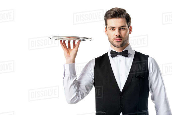 Portrait of handsome waiter in suit vest with empty serving tray ...