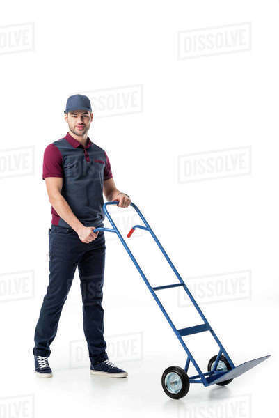 Delivery man in uniform with empty hand truck isolated on white ...