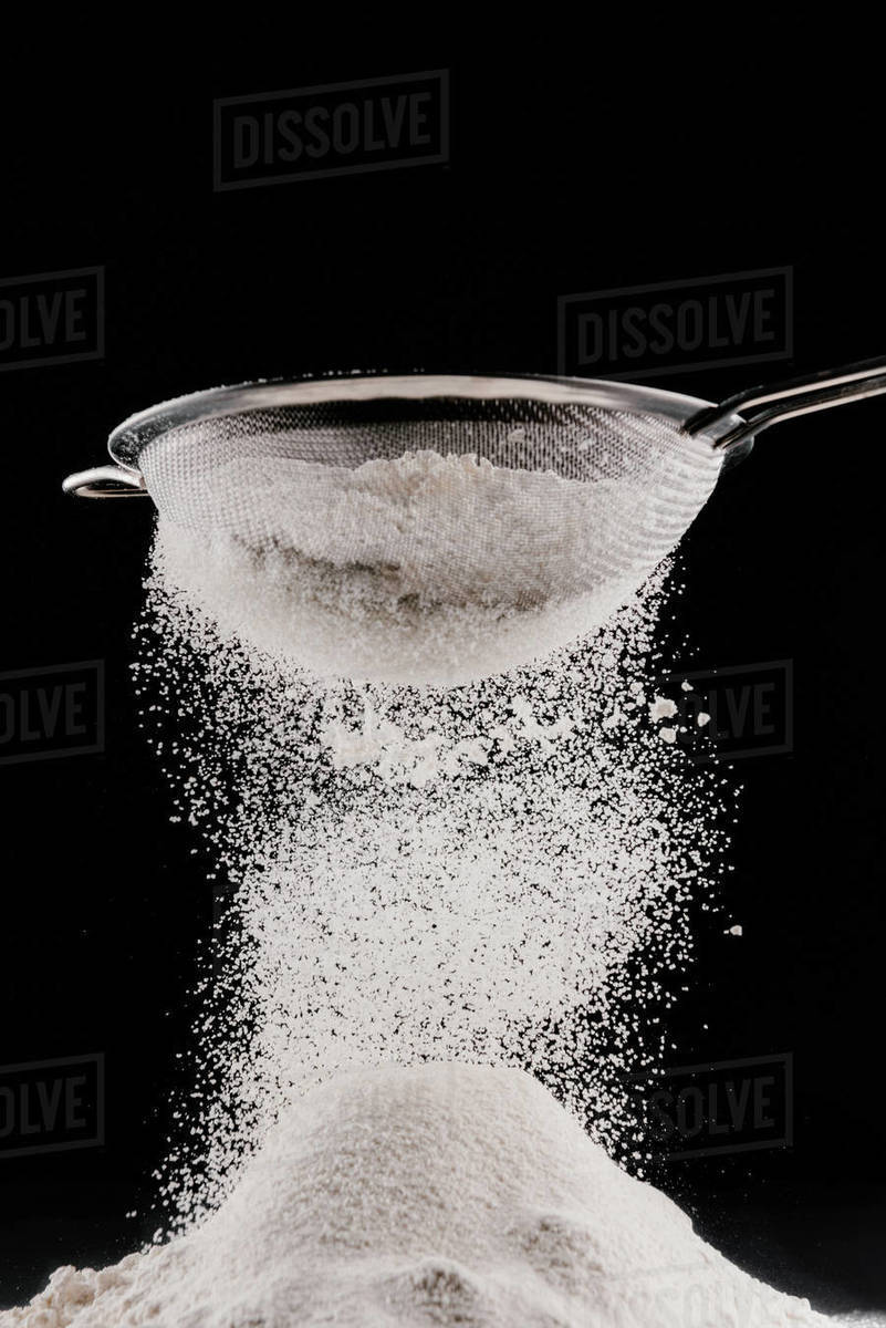 White flour falling from sieve on pile isolated on black - Royalty-free ...