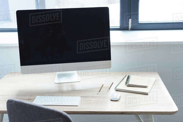 Computer with blank monitor on working table - Stock Photo - Dissolve