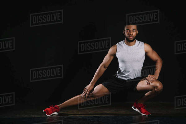 Athletic young African American man in sportswear exercising and ...