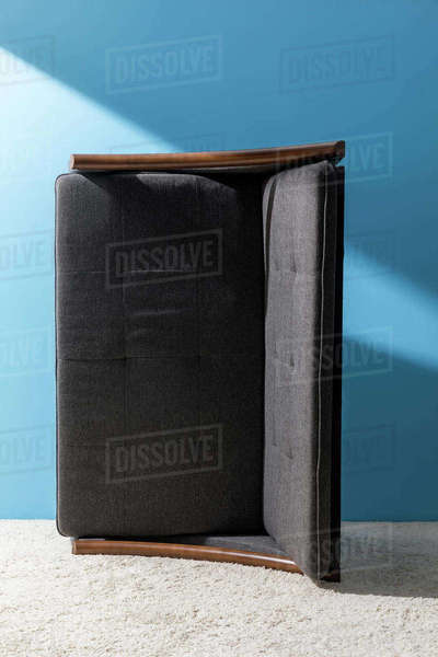 Couch flipped on side in front of blue wall - Royalty-free Stock Photo ...