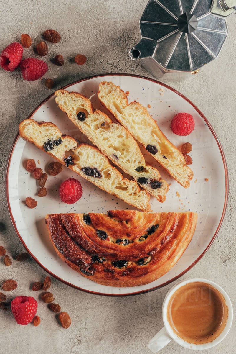 Top view of coffee maker, cup of coffee and sweet pastry on plate on ...