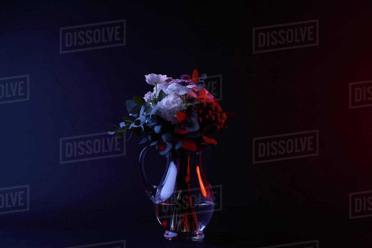 bouquet of different flowers in reflecting glass vase on dark - Royalty ...