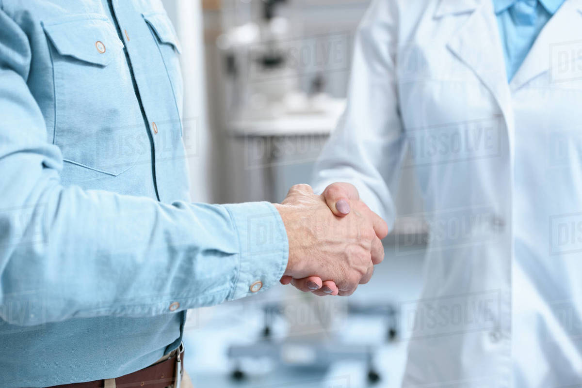 Partial view of man shaking hands with doctor in clinic - Royalty-free ...
