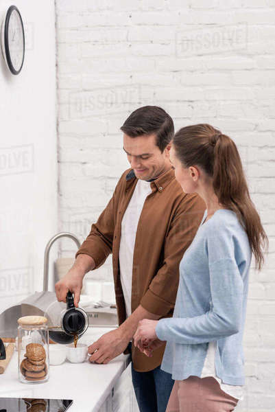 Happy man pouring coffee for wife and himself in morning - Royalty-free ...