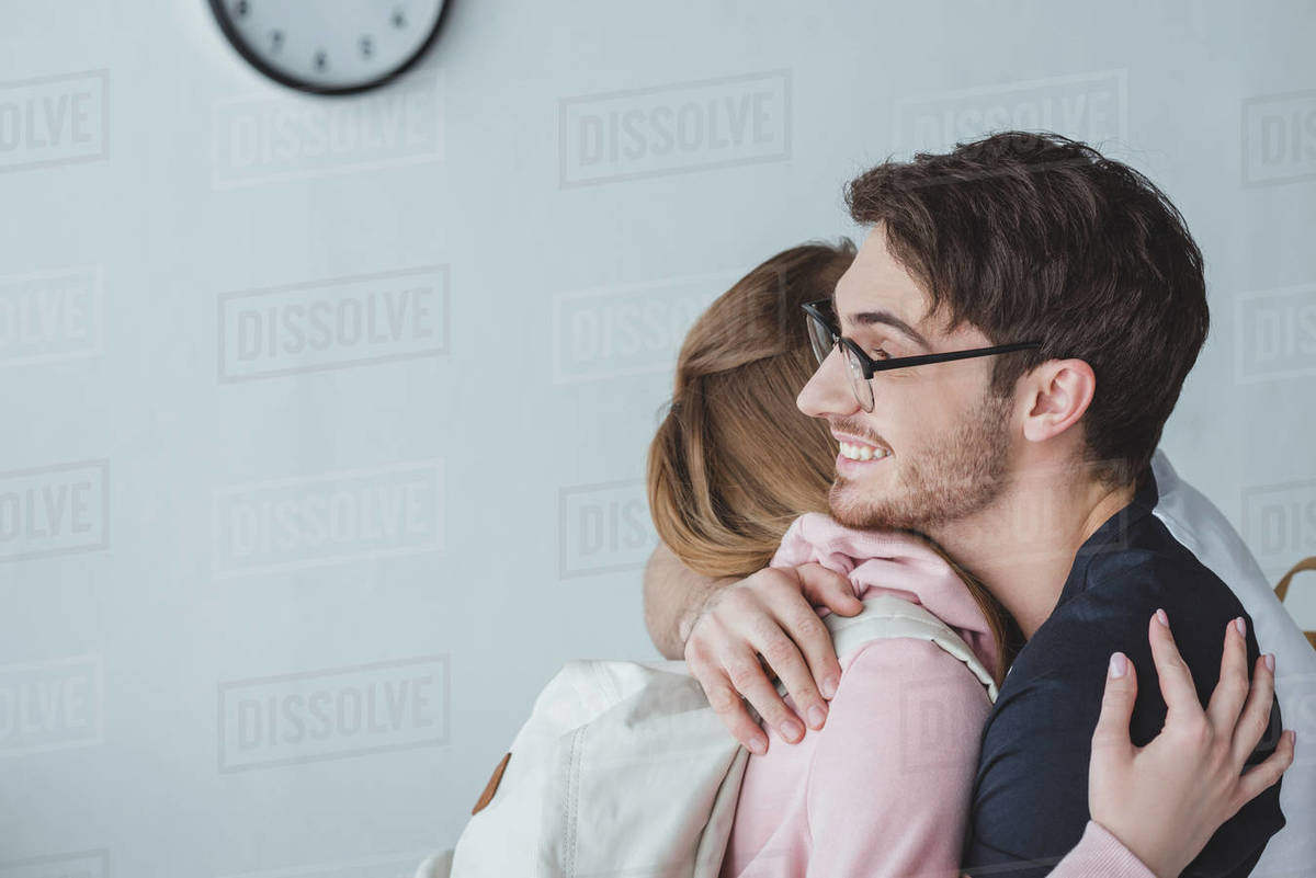 Happy man hugging girl with backpack - Royalty-free Stock Photo | Dissolve