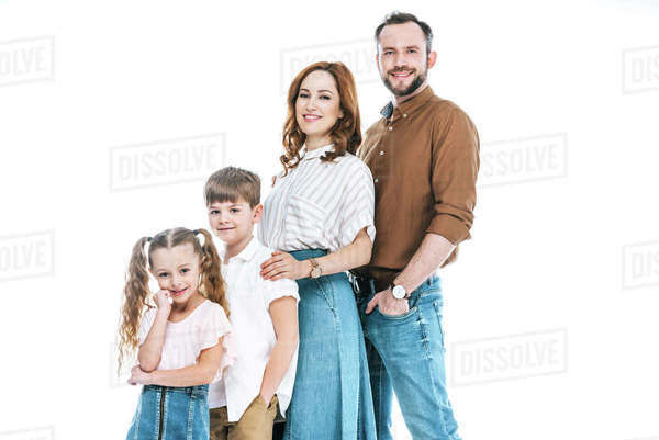 Happy family with two children standing together and smiling at camera ...