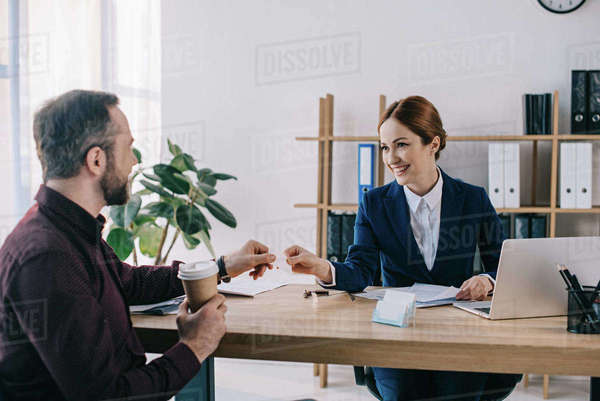 Smiling businesswoman giving blank card to client with coffee to go at ...