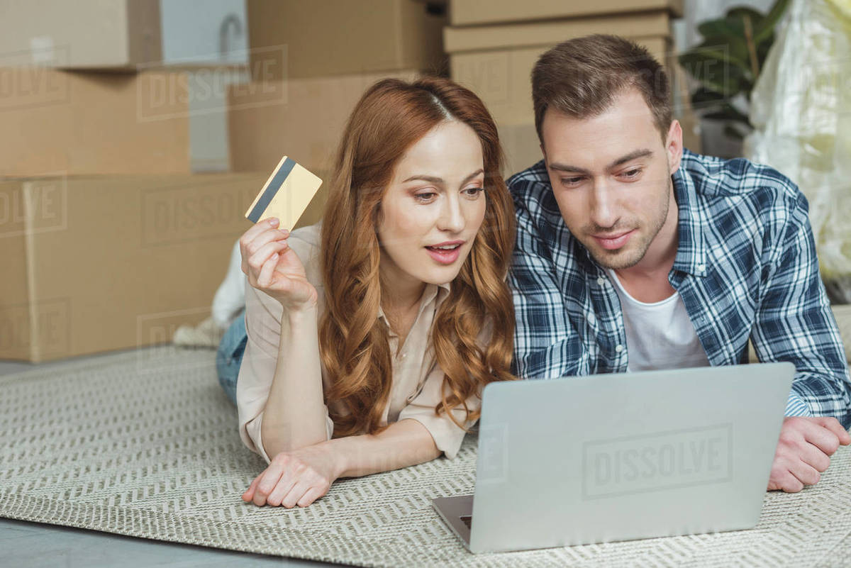 Couple buying goods online together at new home, moving house concept ...