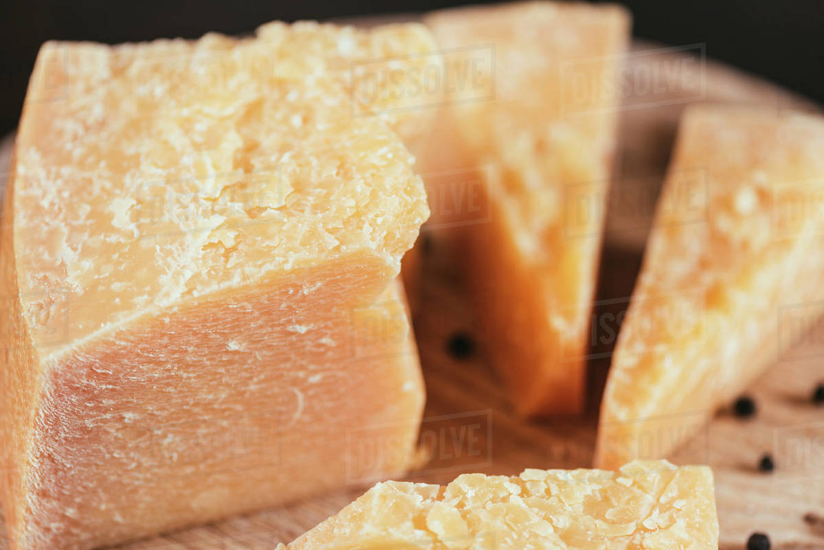 Close-up view of gourmet parmesan cheese with peppercorns on wooden ...