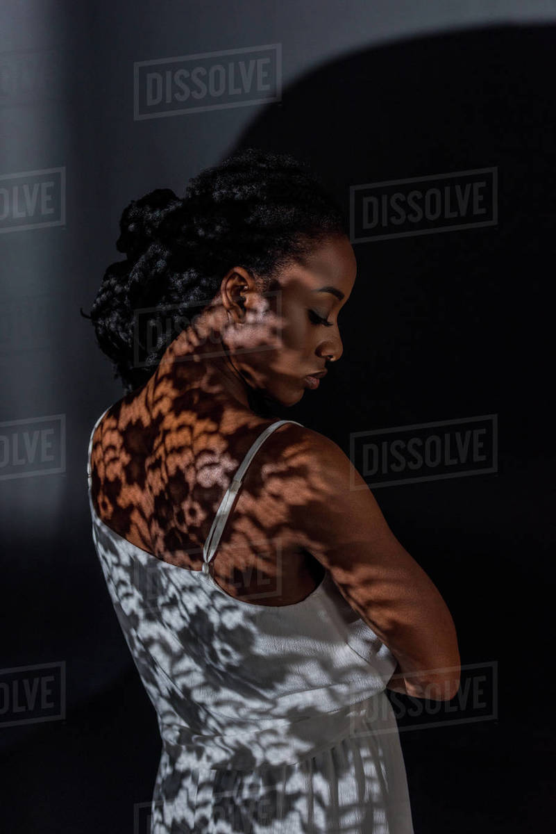 Rear view of young African American woman with shadow on back - Royalty ...