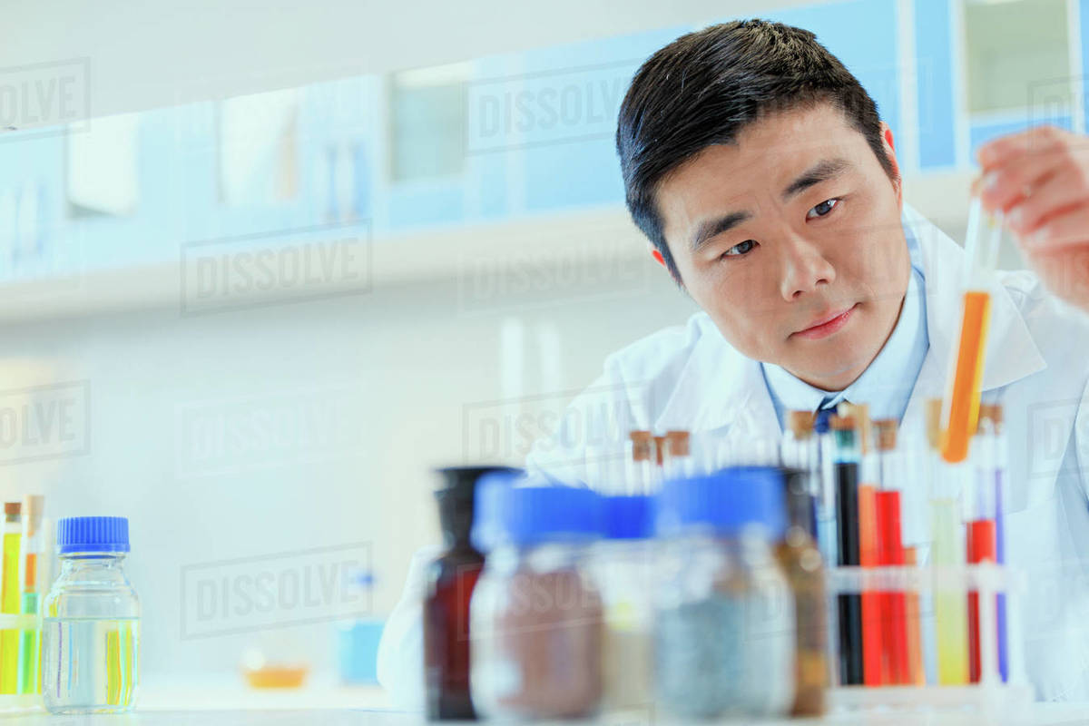Young asian doctor in uniform working at testing laboratory, chemical ...