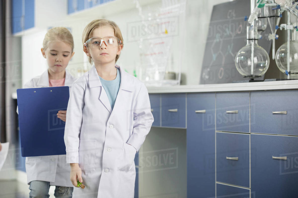 Schoolchildren in lab coats studying in chemical laboratory - Royalty ...
