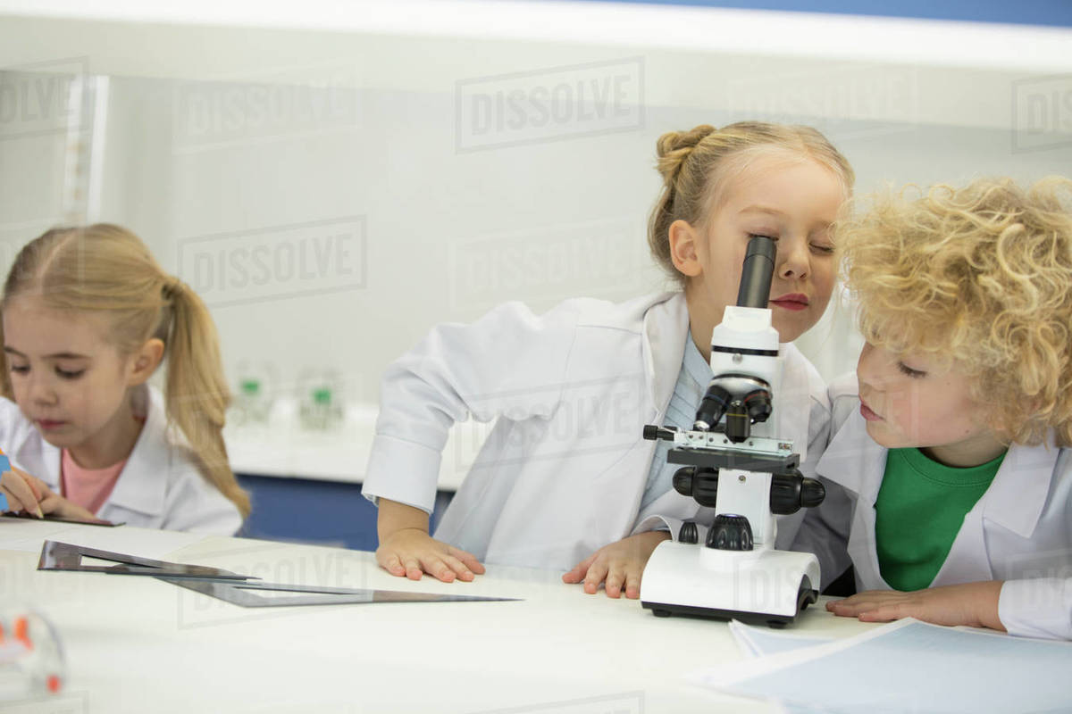 Little kids looking through microscope in science class - Royalty-free ...