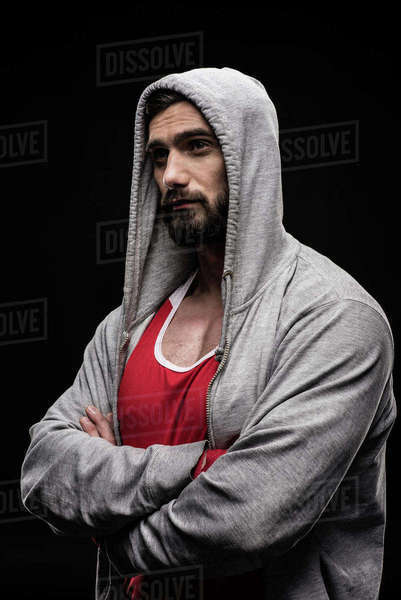 Confident young boxer standing with arms crossed on black - Stock Photo ...