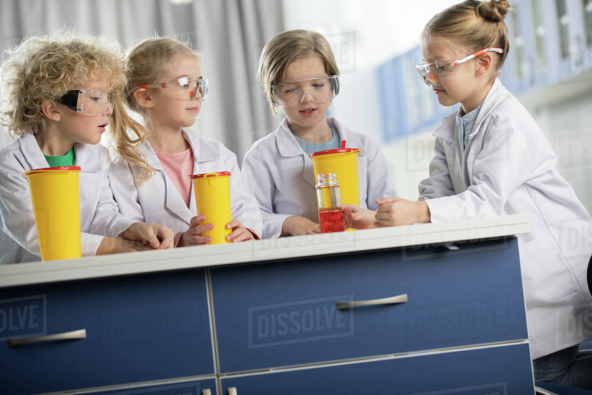 Kids in protective glasses making experiment in laboratory - Royalty ...