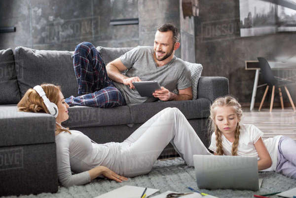 Happy family using digital devices at home - Royalty-free Stock Photo ...