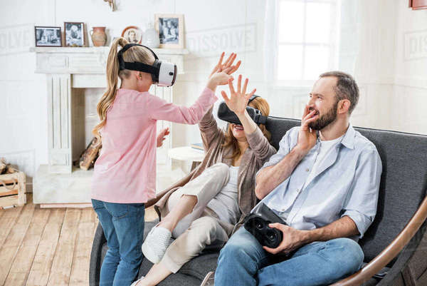 Happy family using virtual reality headsets at home - Royalty-free ...