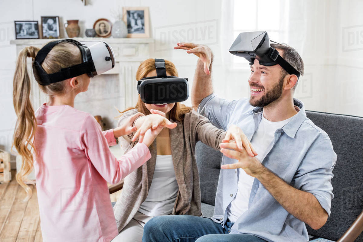 Happy family having fun together in virtual reality headsets - Royalty ...