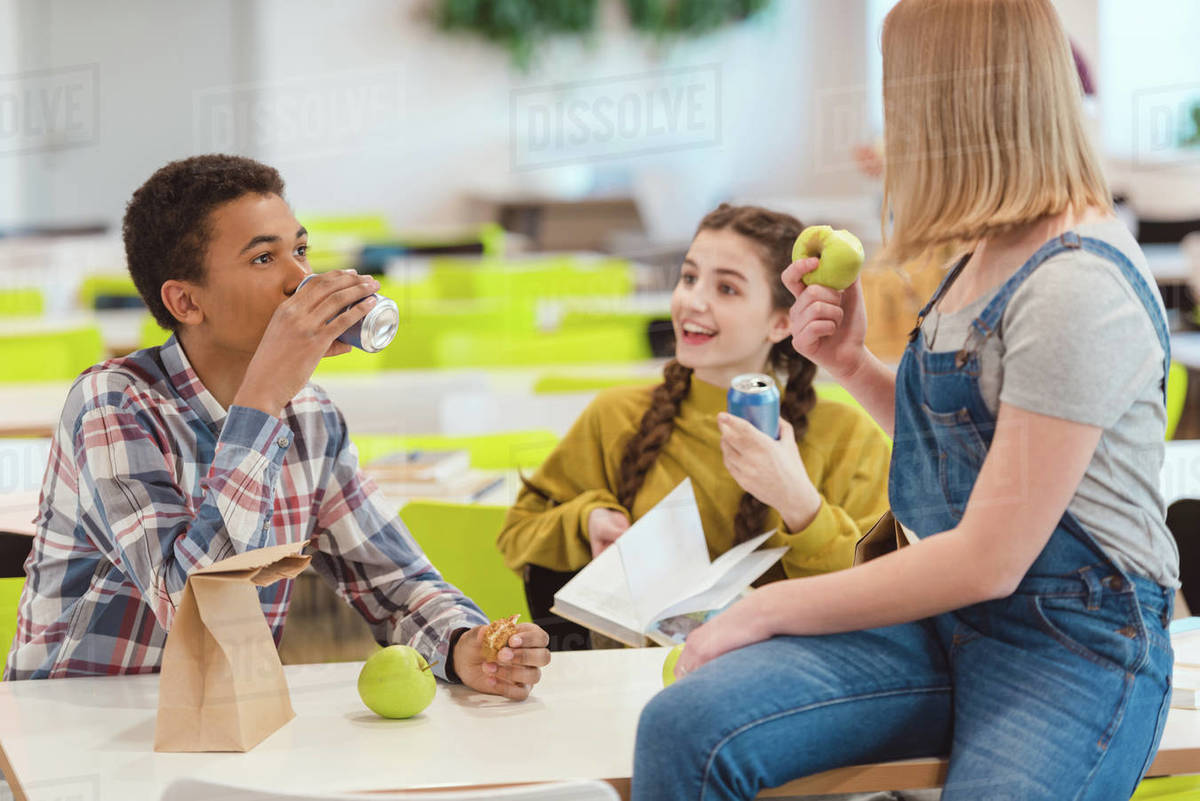 High school students taking lunch together at school cafeteria ...