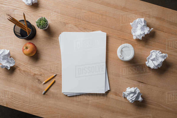 Top view of stacked blank papers on wooden table with crumpled papers ...