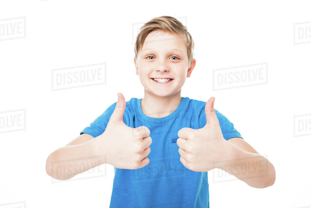 Cheerful little boy showing thumbs up and smiling at camera isolated on ...