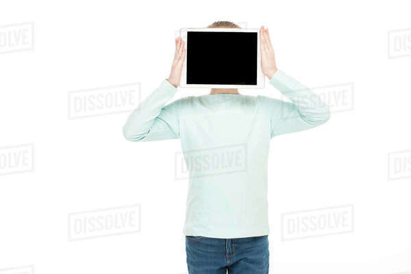 Little girl hiding face behind digital tablet with blank screen ...
