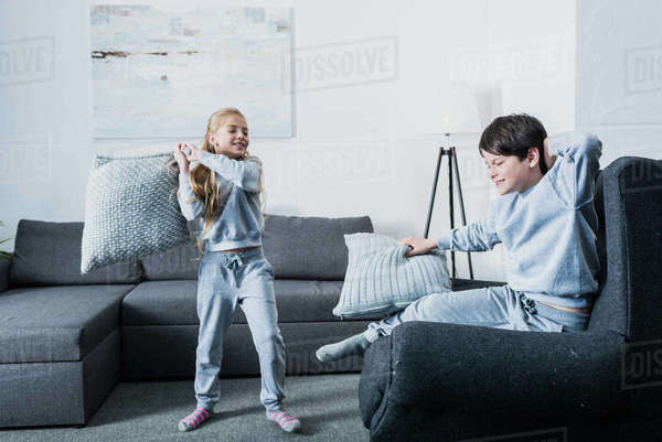Cute little siblings in pajamas fighting with pillows at home - Stock ...