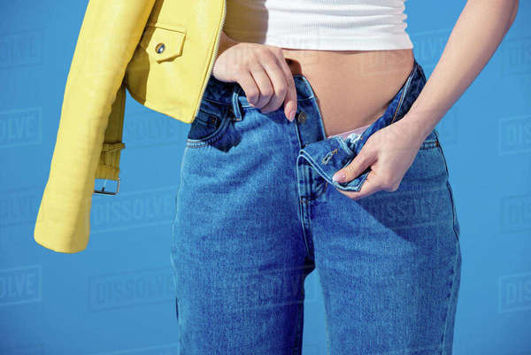 Cropped image of stylish girl unbuttoning jeans isolated on blue ...