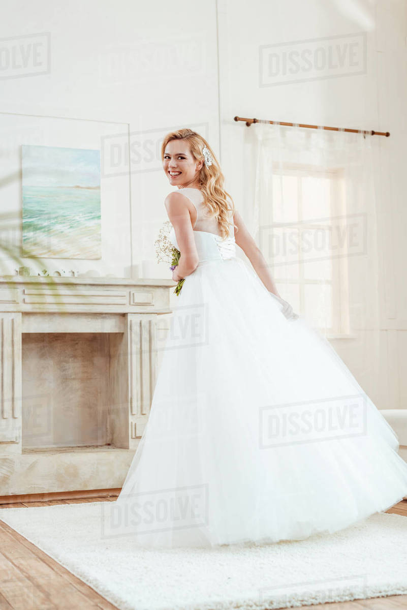 Beautiful young bride in wedding dress in living room - Stock Photo ...