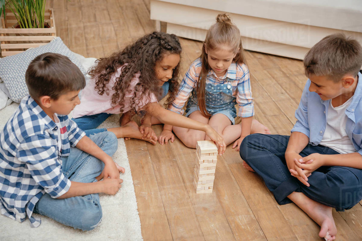 Multicultural group of children playing blocks wood game together at ...