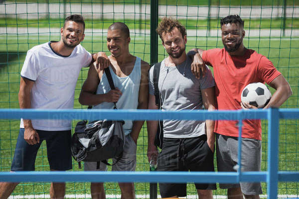 Multicultural soccer team resting on stadium together before game ...