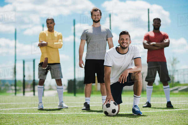 Multiethnic soccer team standing on soccer pitch after game - Royalty ...