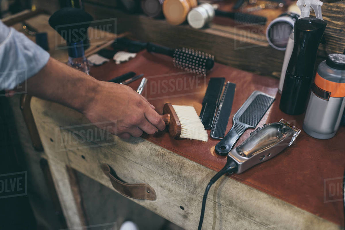 Barber cleaning his workplace with brush, his professional equipment ...