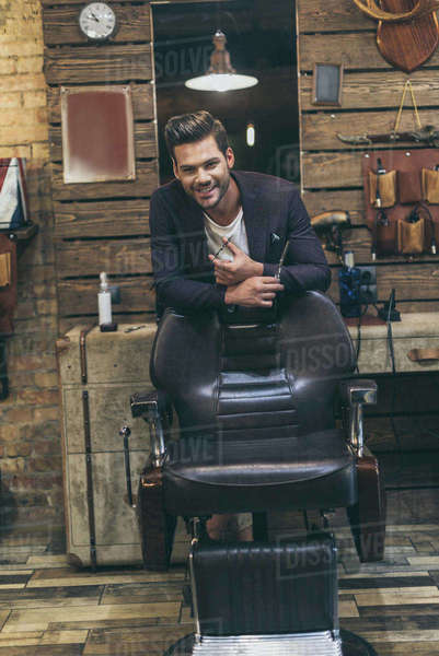 Portrait of handsome caucasian male barber with fashionable hairstyle ...