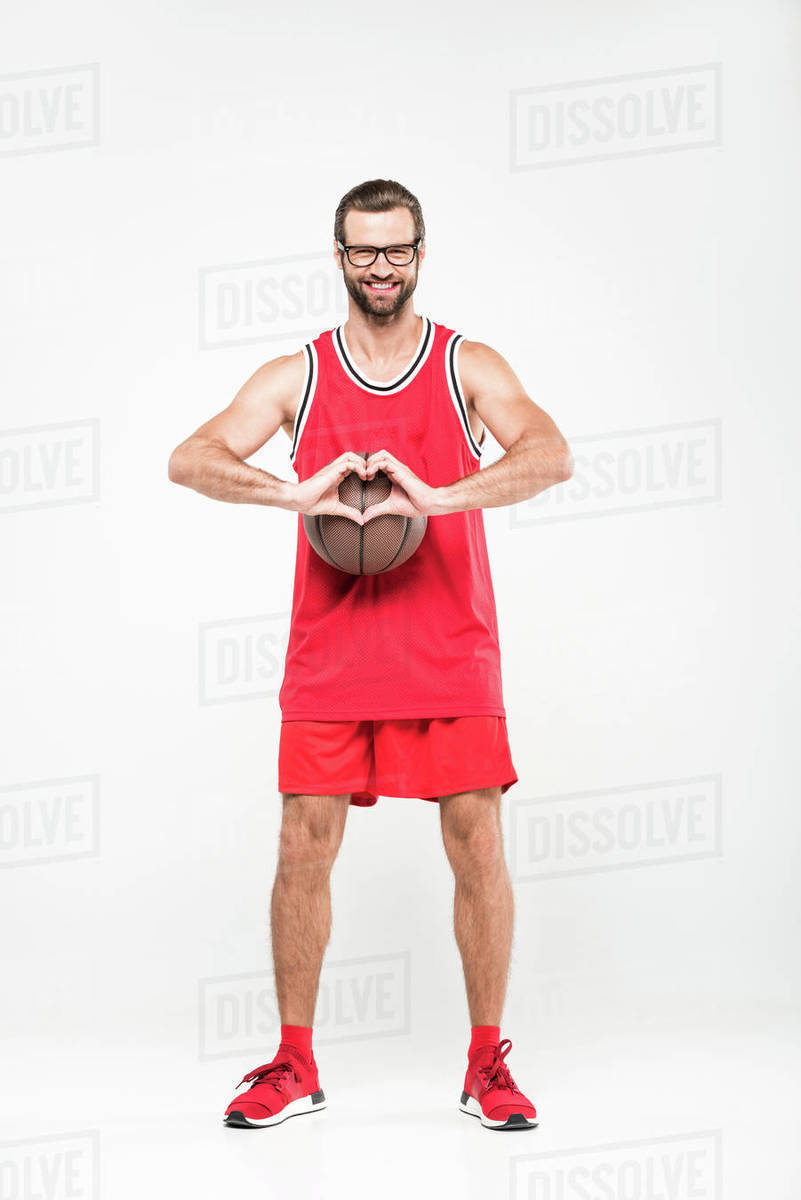 Smiling basketball player with ball showing heart symbol, isolated on ...